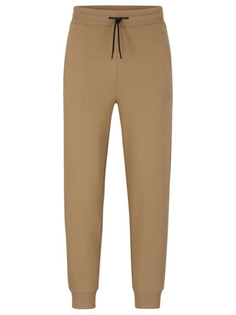 HUGO CUFFED TRACKSUIT BOTTOMS IN FRENCH TERRY WITH LOGO BADGE | REVERSIBLE